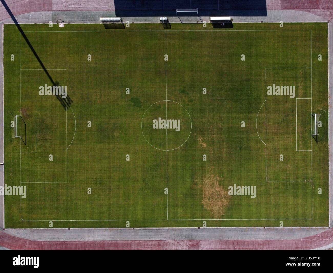 Overhead view of a full size football field in bad shape with patchy ...