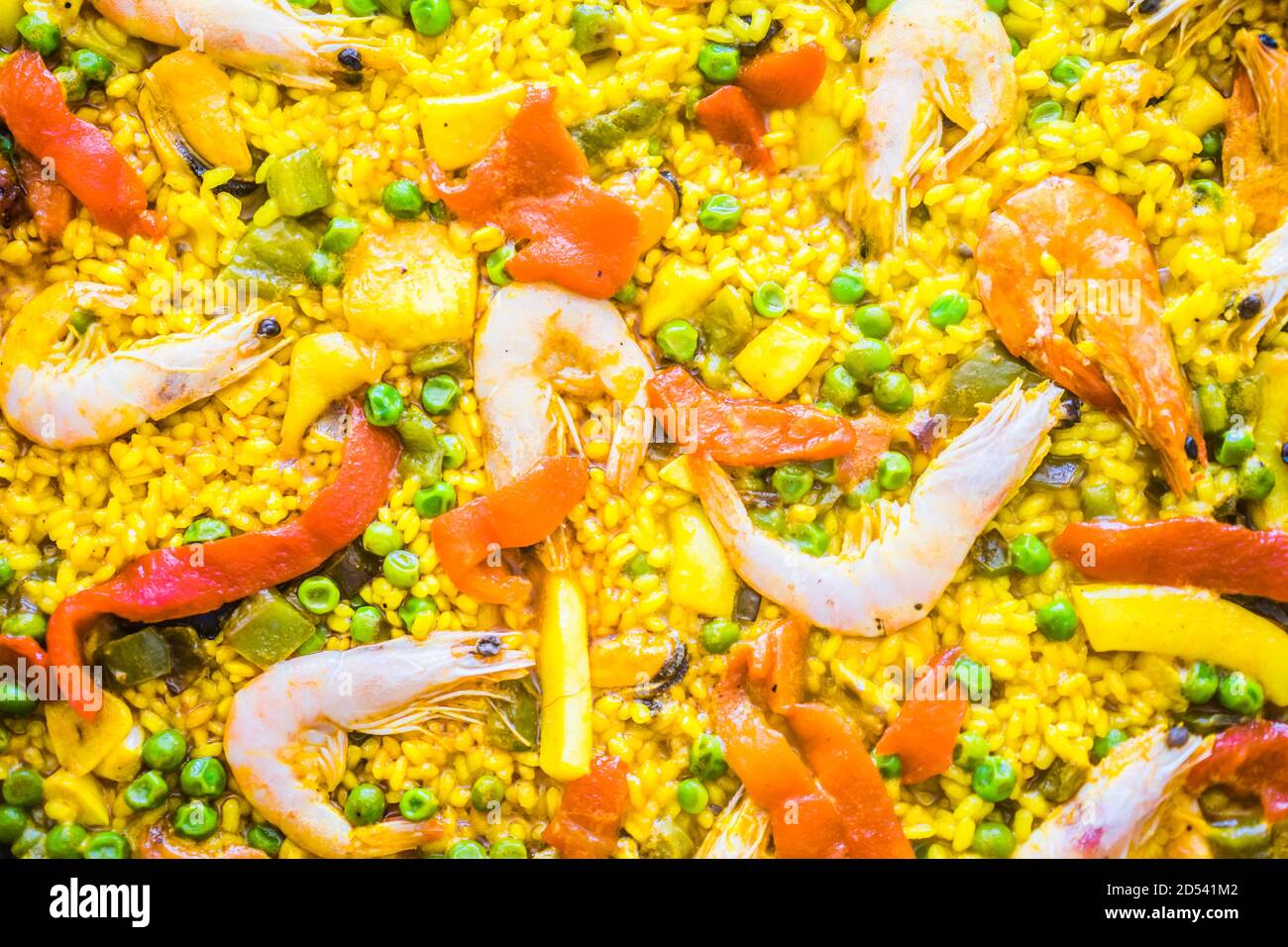 Close-up shot of a delicious paella with yellow rice and seafood on a ...