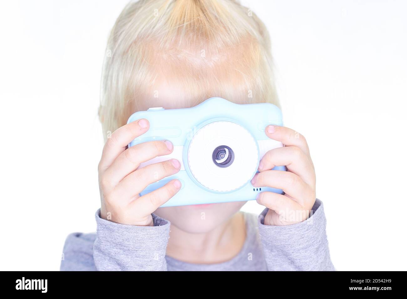 Portrait of a little girl holding a child's camera in isolation Stock ...