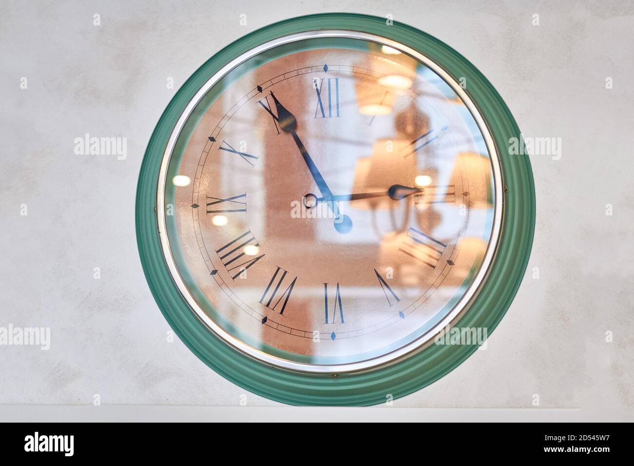 Large wall clock which reflects the room. Watch glass reflection light ...