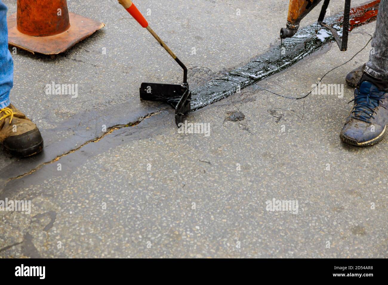 Road surface restoration work in the worker performs on road patcher ...
