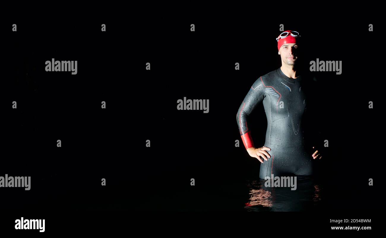 authentic triathlete swimmer having a break during hard training on ...