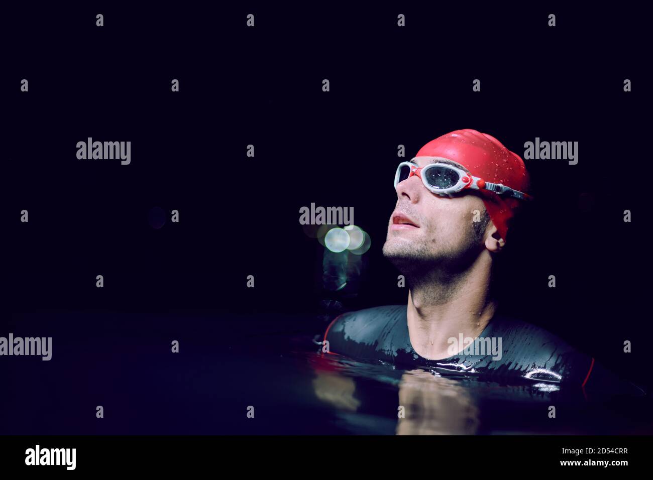 authentic triathlete swimmer having a break during hard training on ...