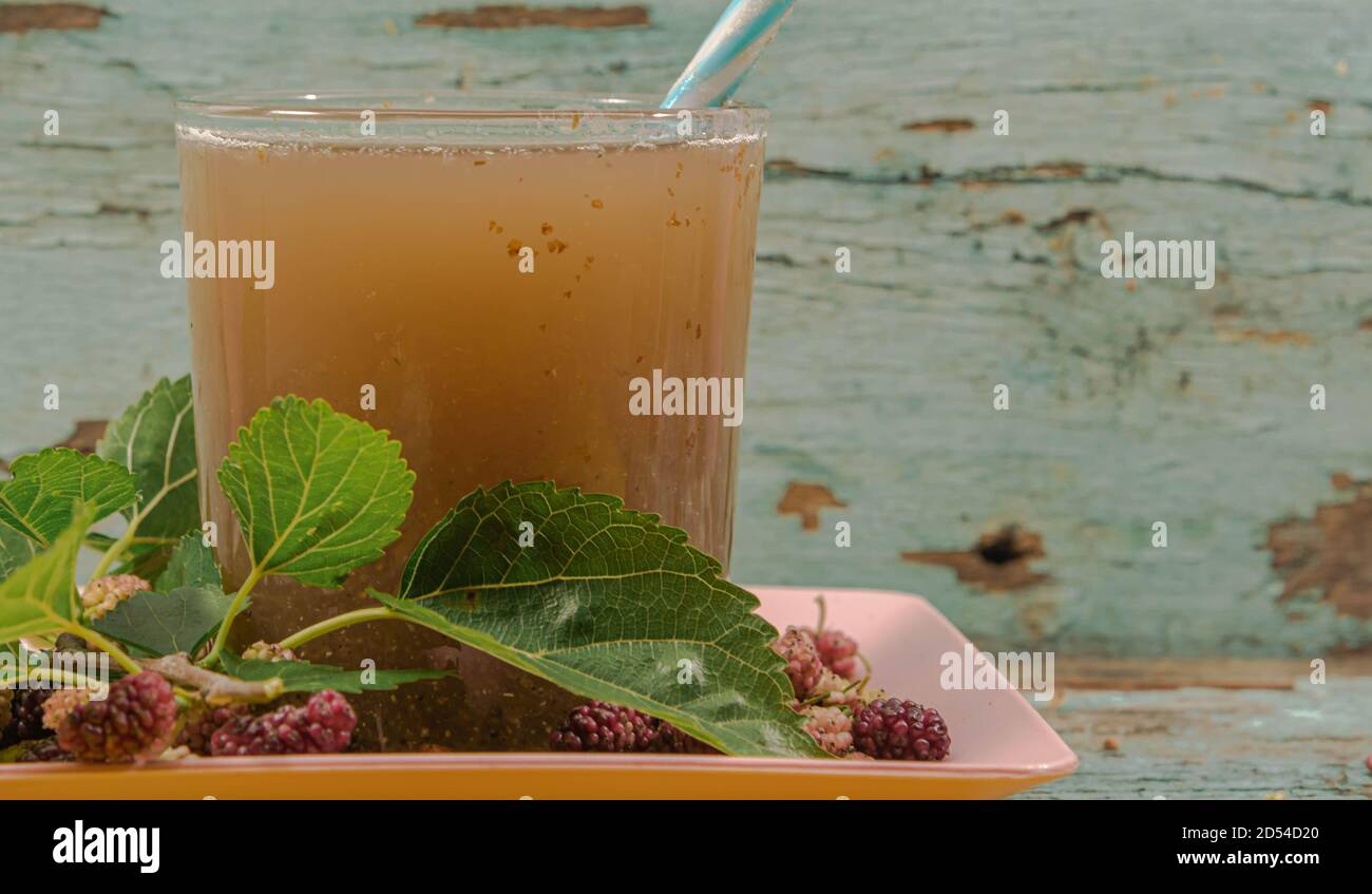 Glass of blackberry juice on tray with fruits and leaves. Detox and ...