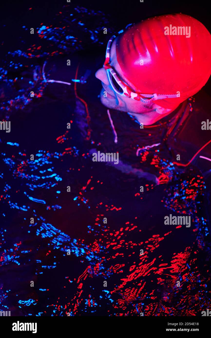 authentic triathlete swimmer having a break during hard training on ...