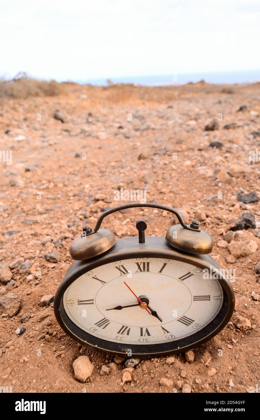 Classic Analog Clock In The Sand Stock Photo - Alamy