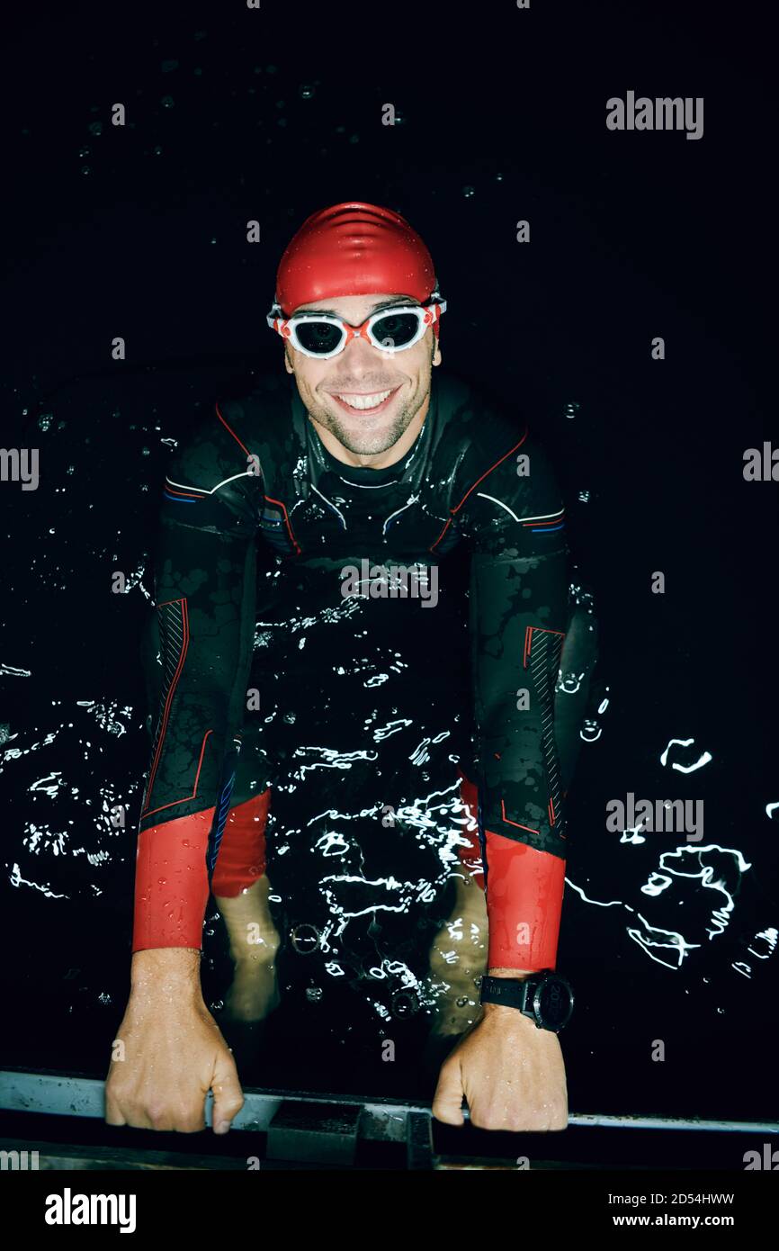 authentic triathlete swimmer having a break during hard training on ...