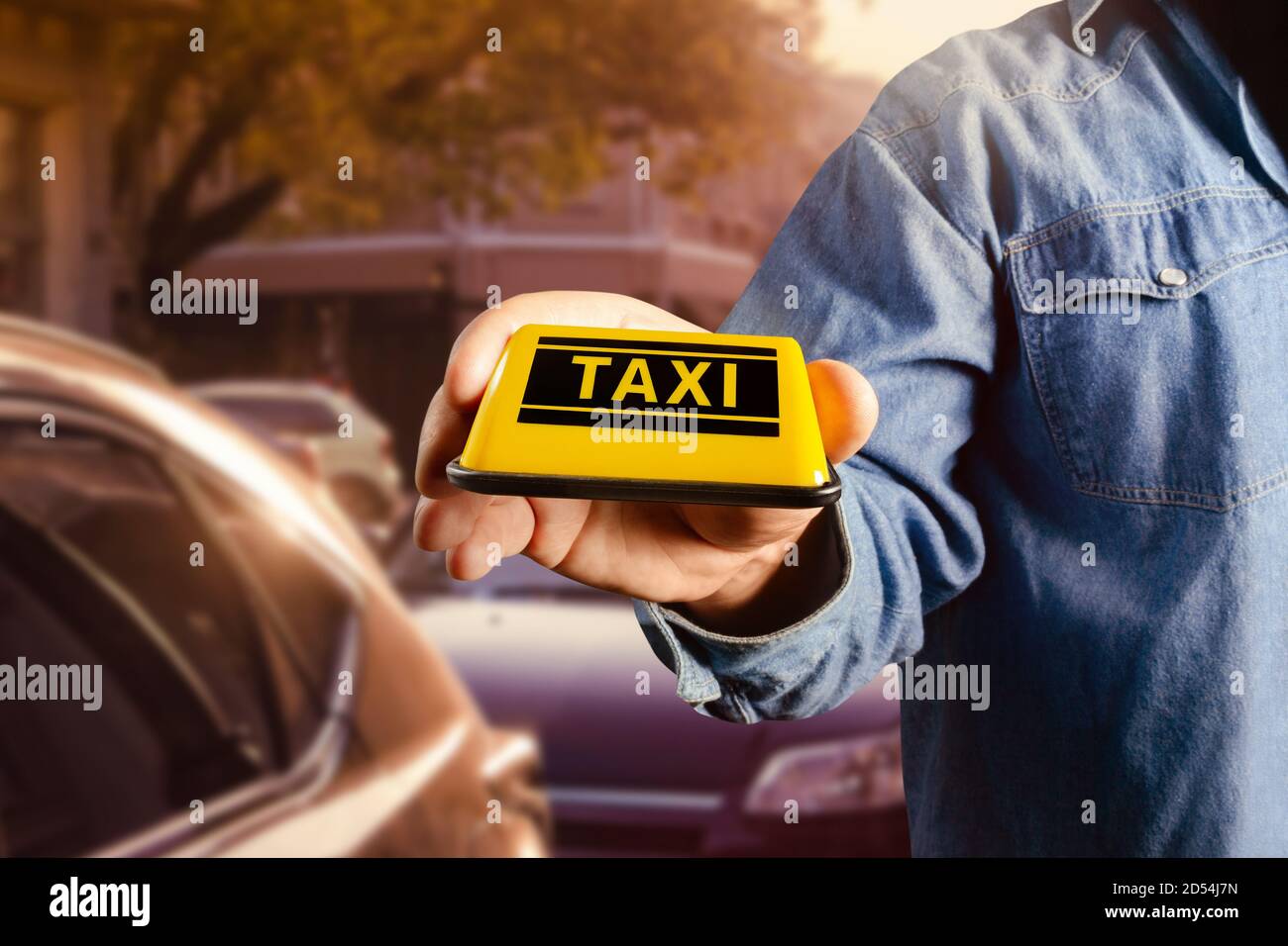 Photo of male hand in shirt holding taxi sign on evening car parking ...