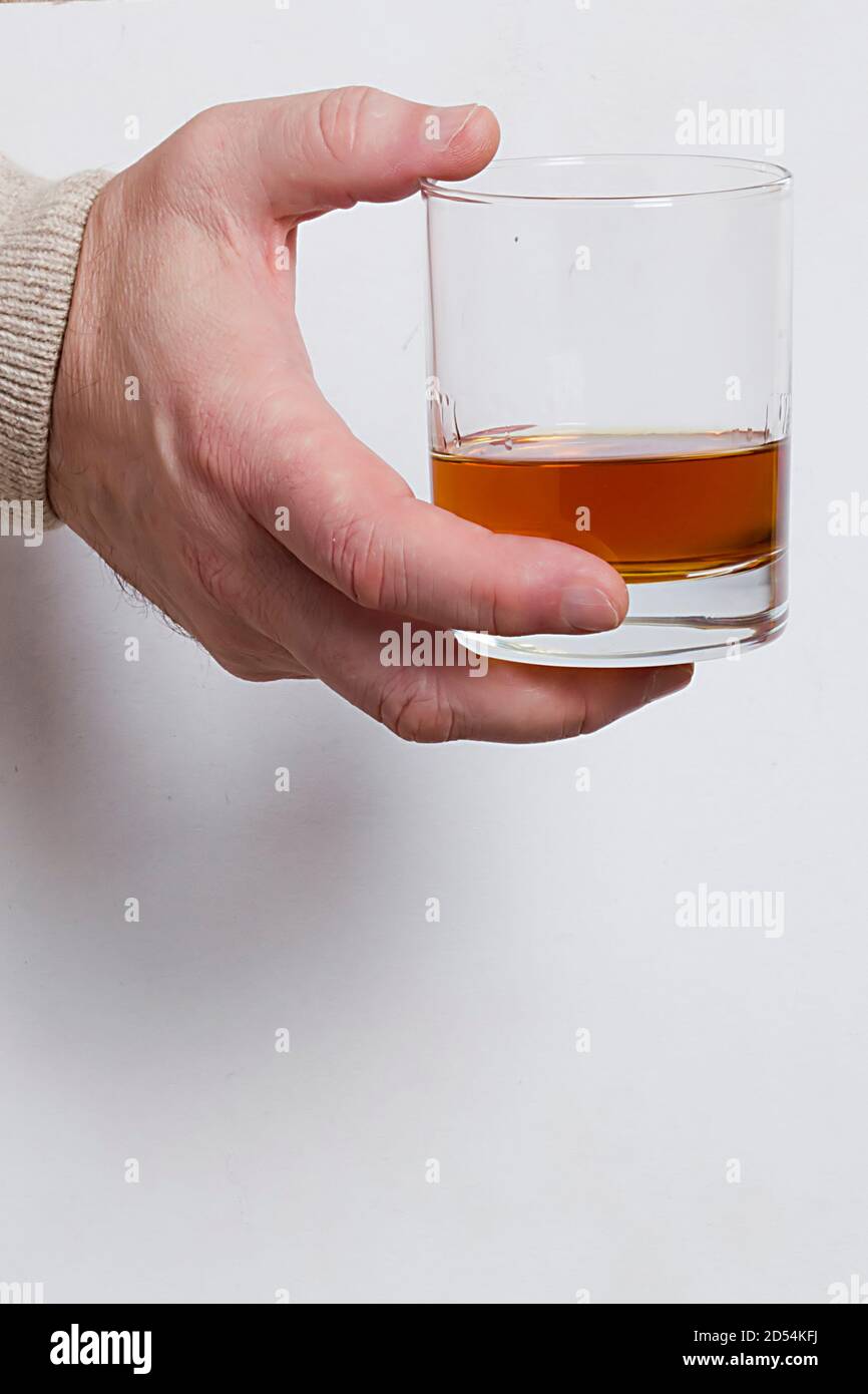 Male hand with a glass of whiskey on a white background Stock Photo - Alamy