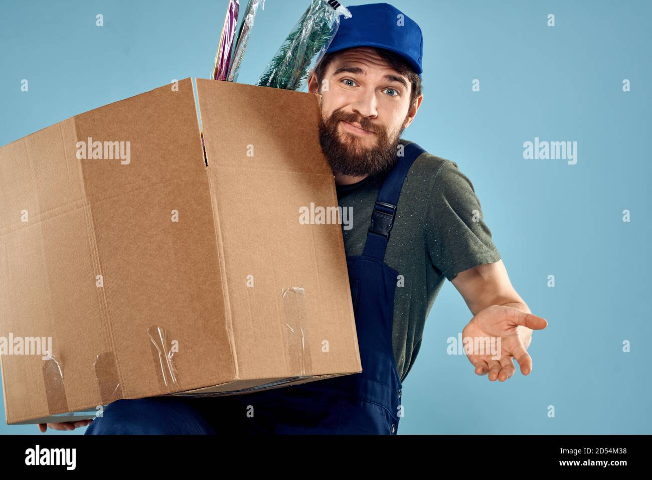 A man in working uniform with boxes in the hands of a carriage delivery ...