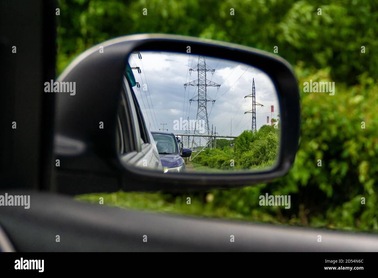 a lot of power transmission towers in the rear-view mirror of a car ...