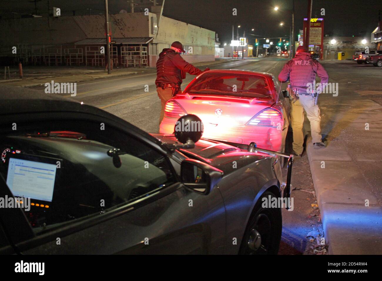 Detroit police officers speak to the driver of a car at night, Detroit ...