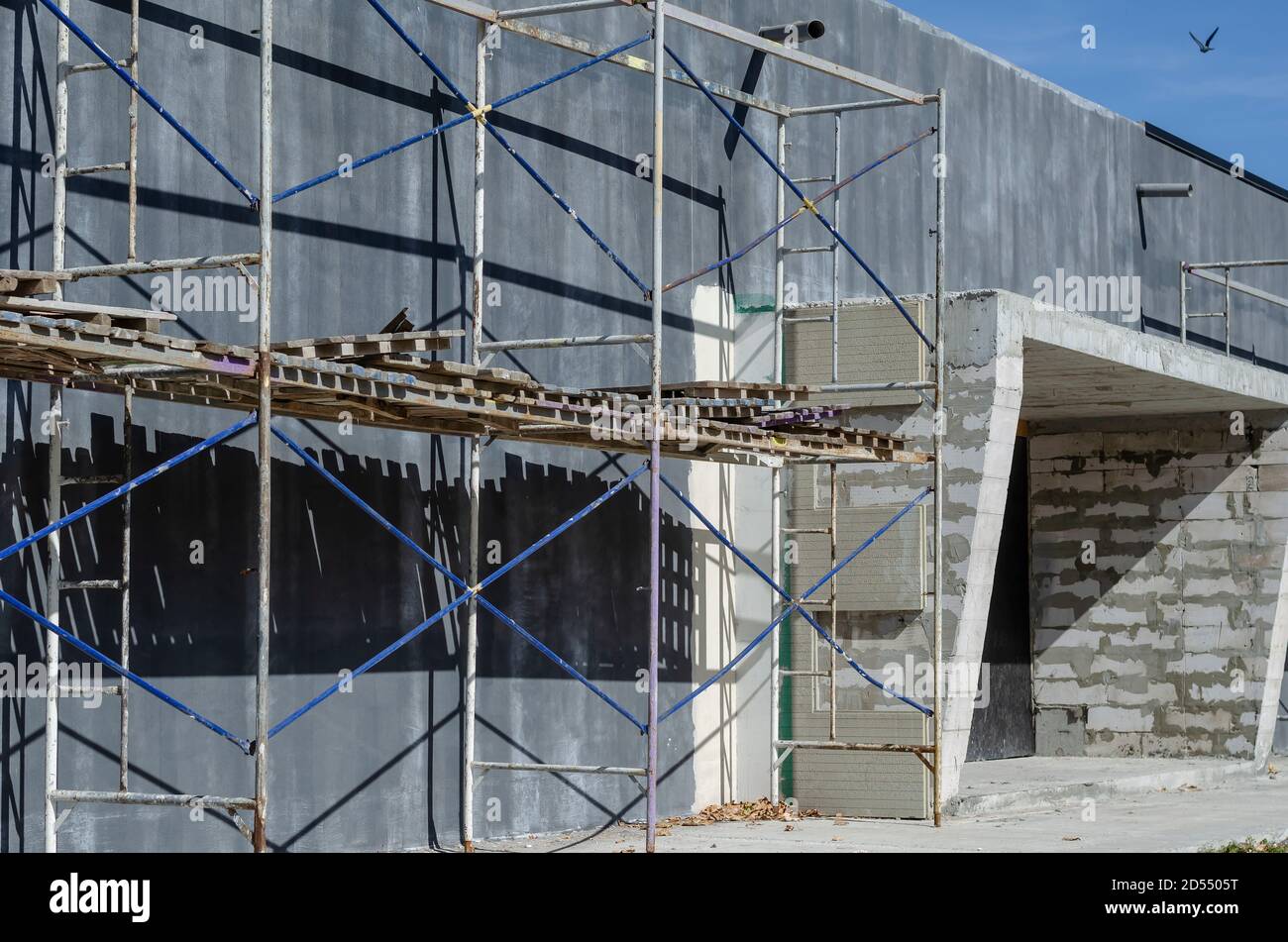 Scaffolding near a gray one-story building. Repair and reconstruction ...