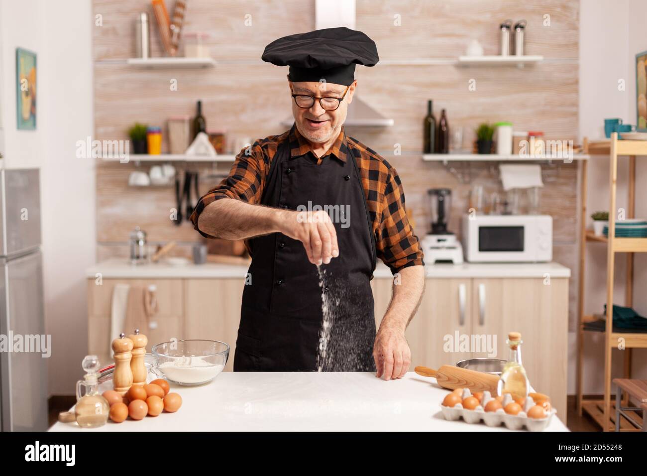 Hand spreading wheat flour on wooden kitchen table for homemade pizza ...