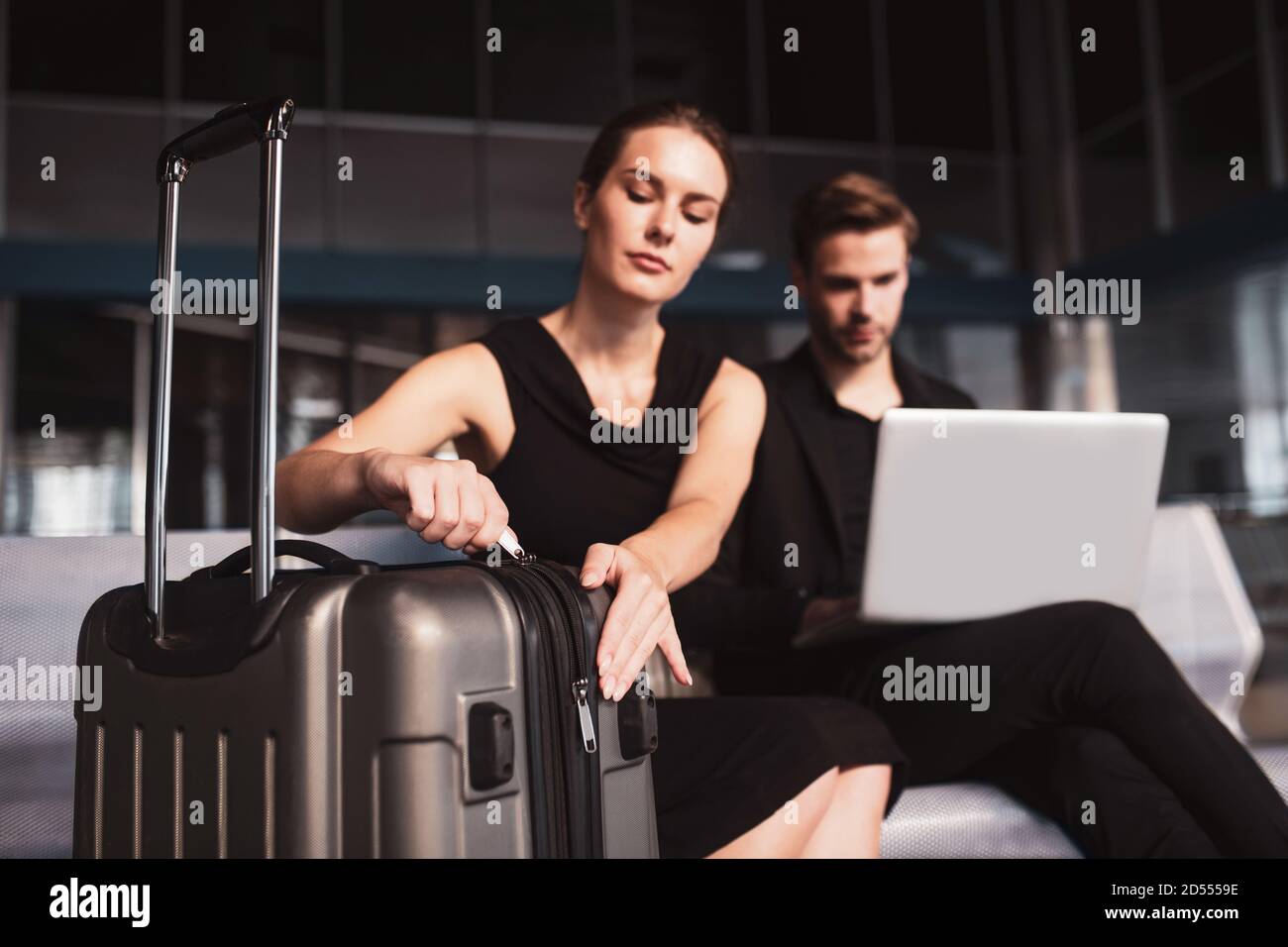 Concentrated woman opening a large brown suitcase Stock Photo - Alamy