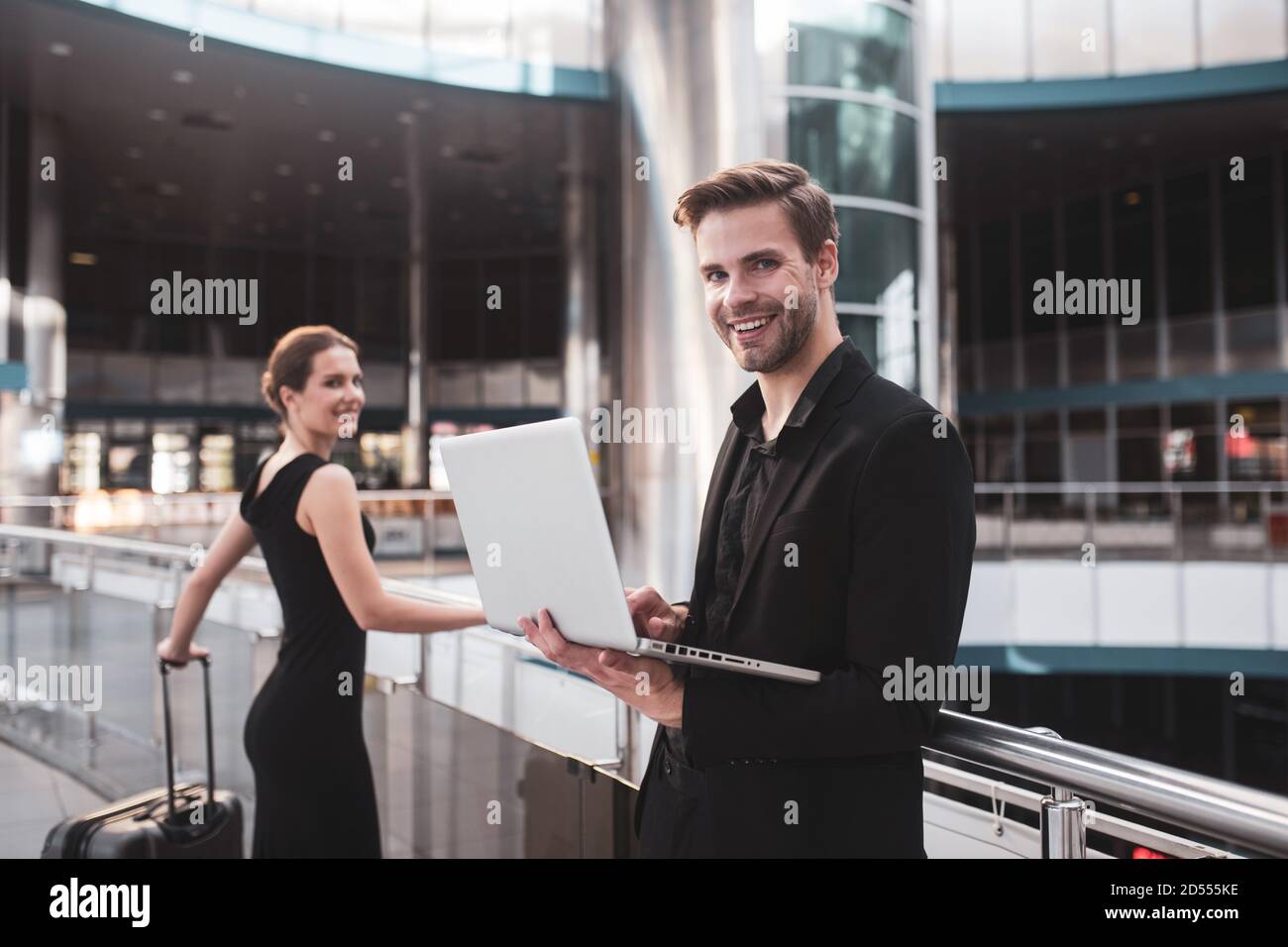 Smiling man working with his computer while travelling Stock Photo - Alamy