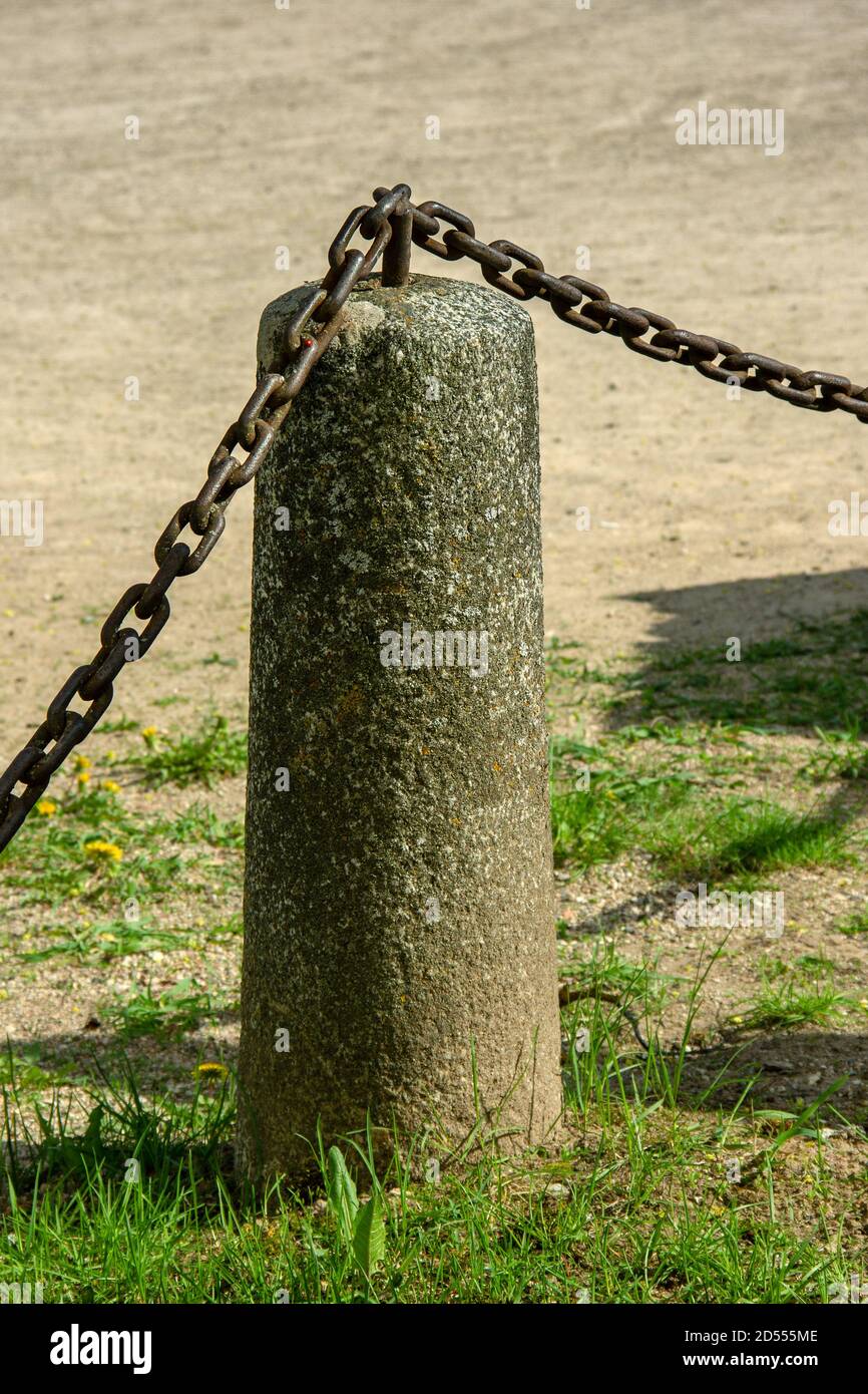 Natural medieval stone pillar with metal chaines Stock Photo - Alamy