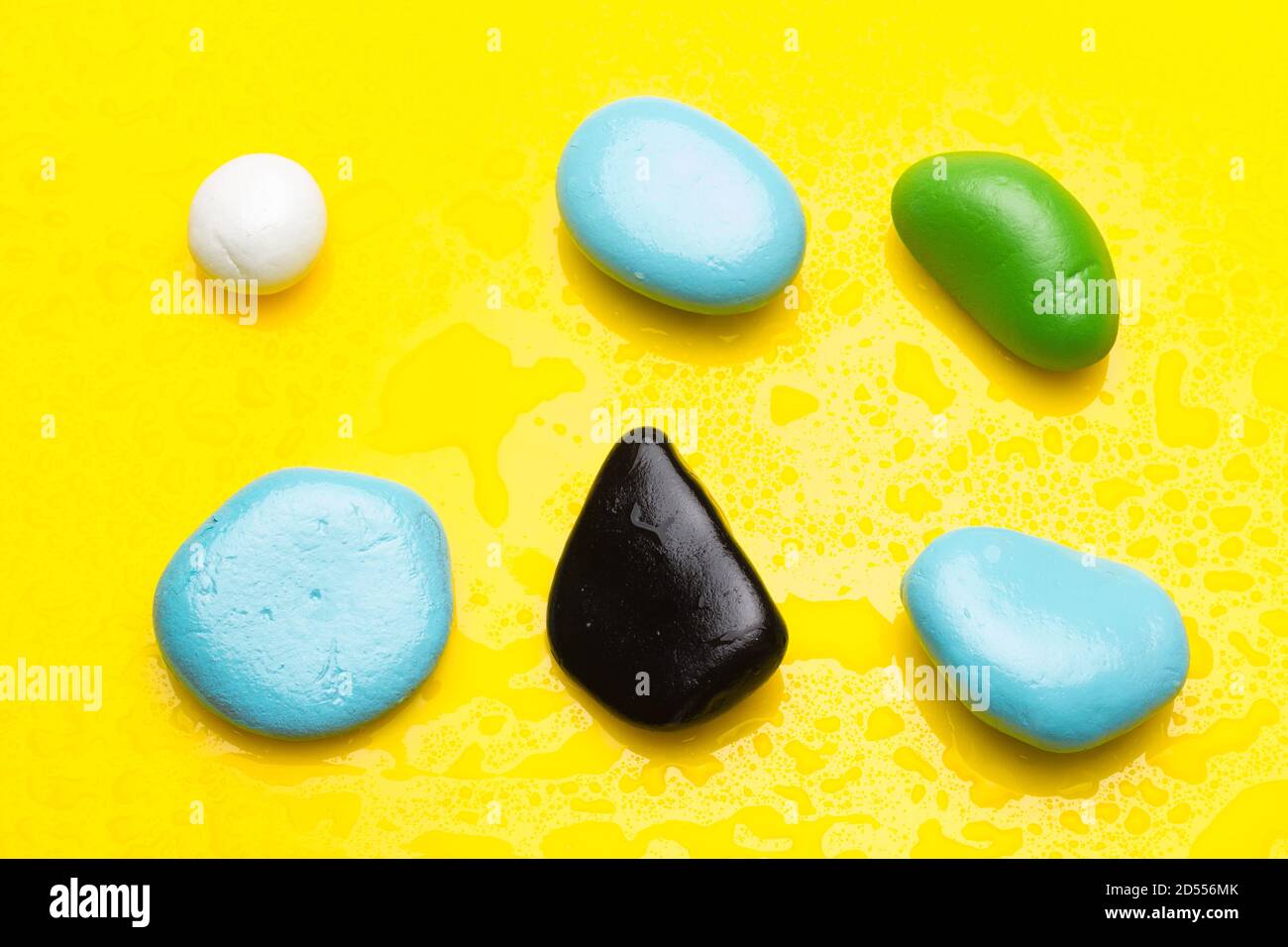 Color stones on a green background; various colors, yellow, black ...