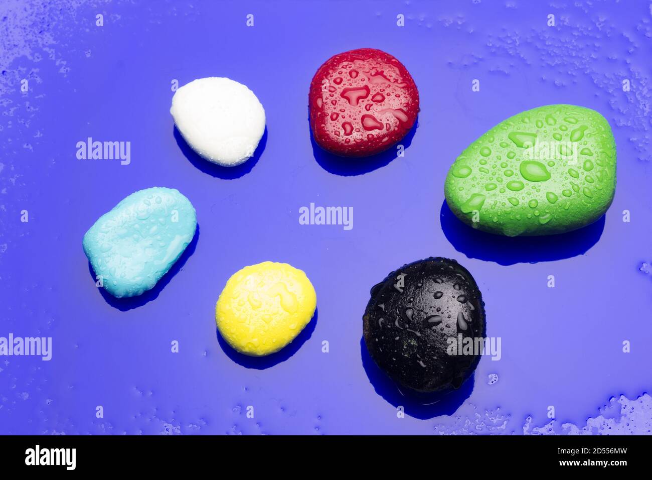 Color stones on a green background; various colors, yellow, black ...