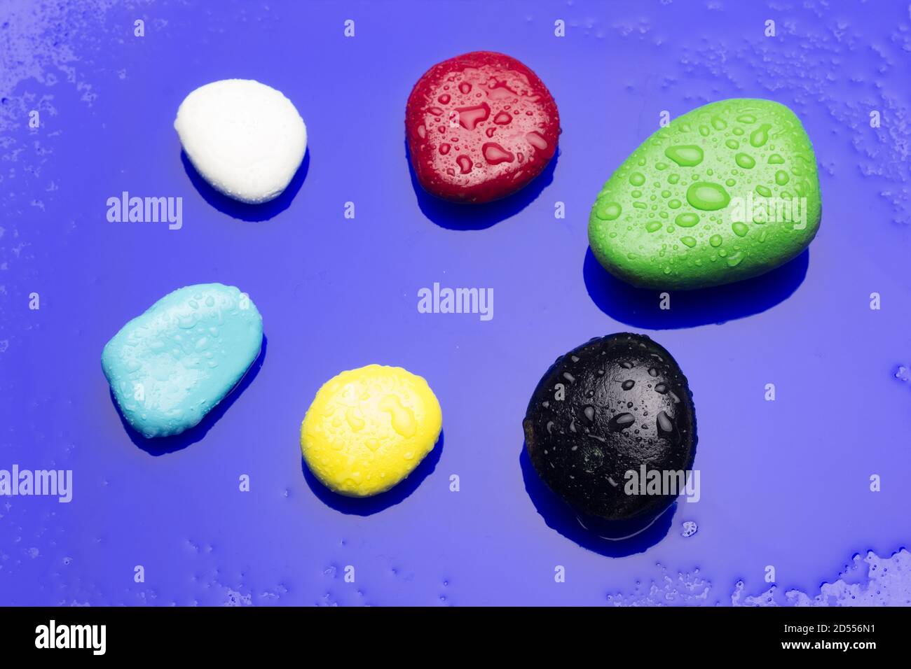 Color stones on a green background; various colors, yellow, black ...