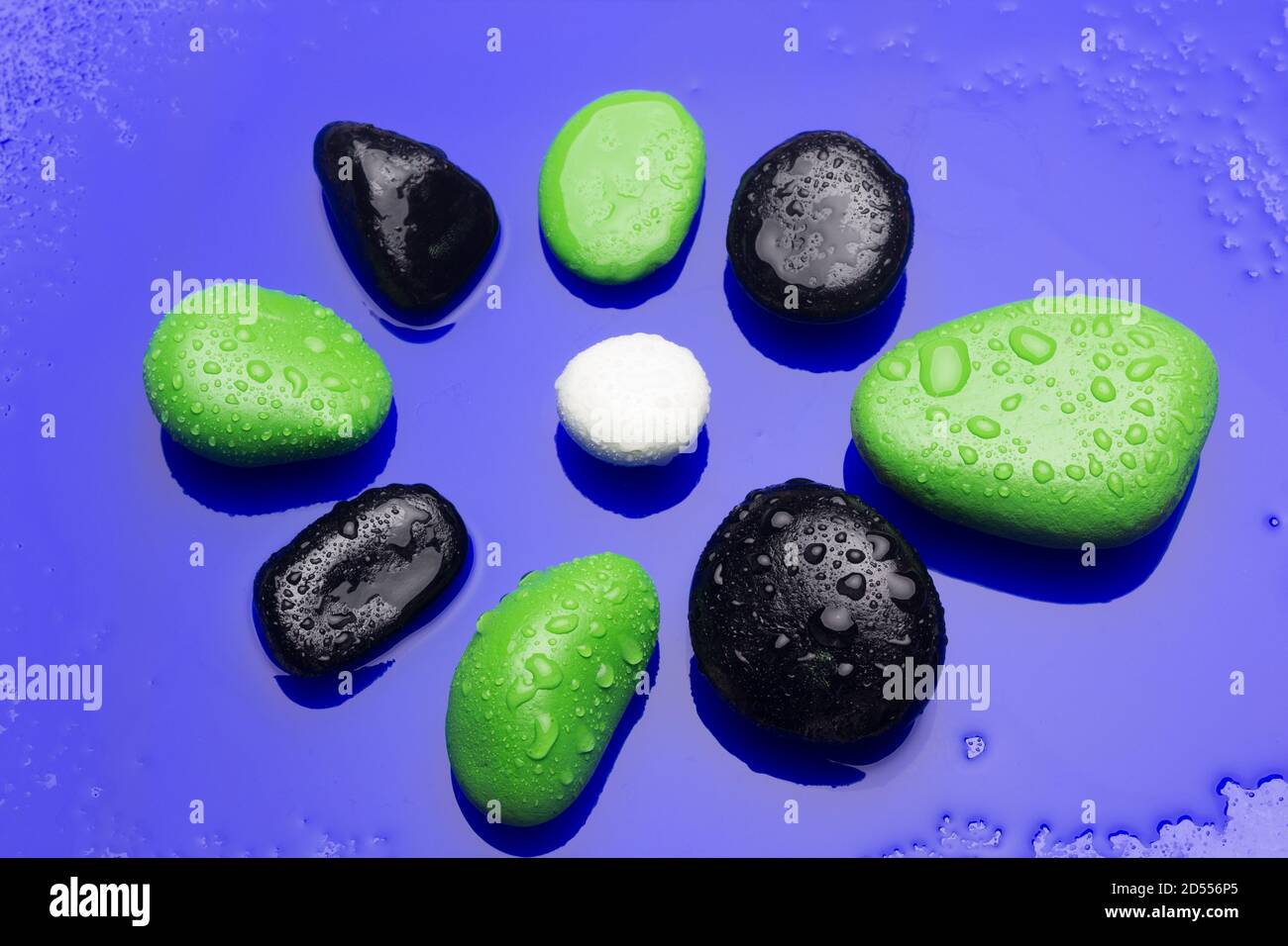 Color stones on a green background; various colors, yellow, black ...