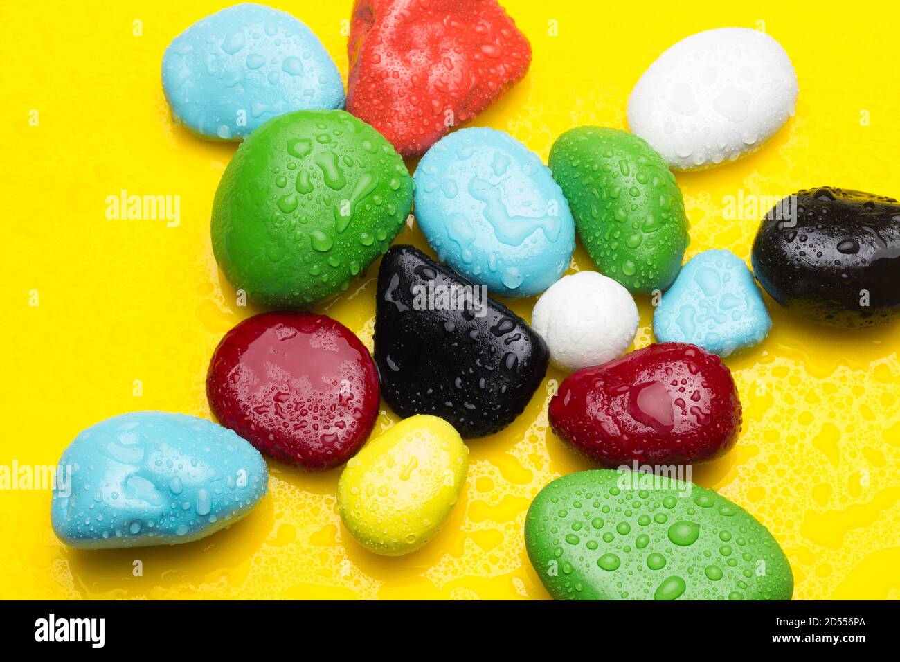 Color stones on a green background; various colors, yellow, black ...