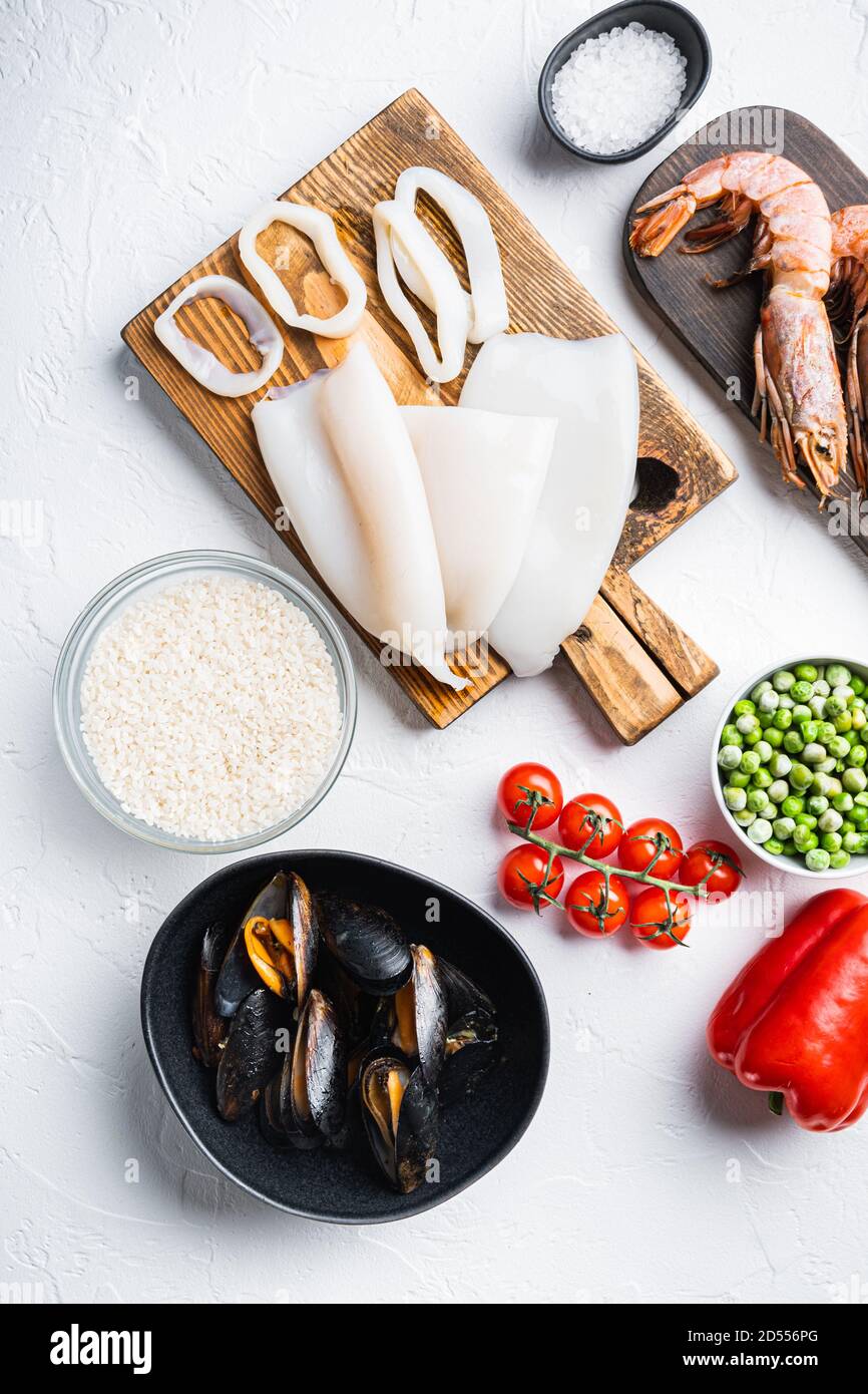 Raw ingredients for paella with seafood on white background, top view ...
