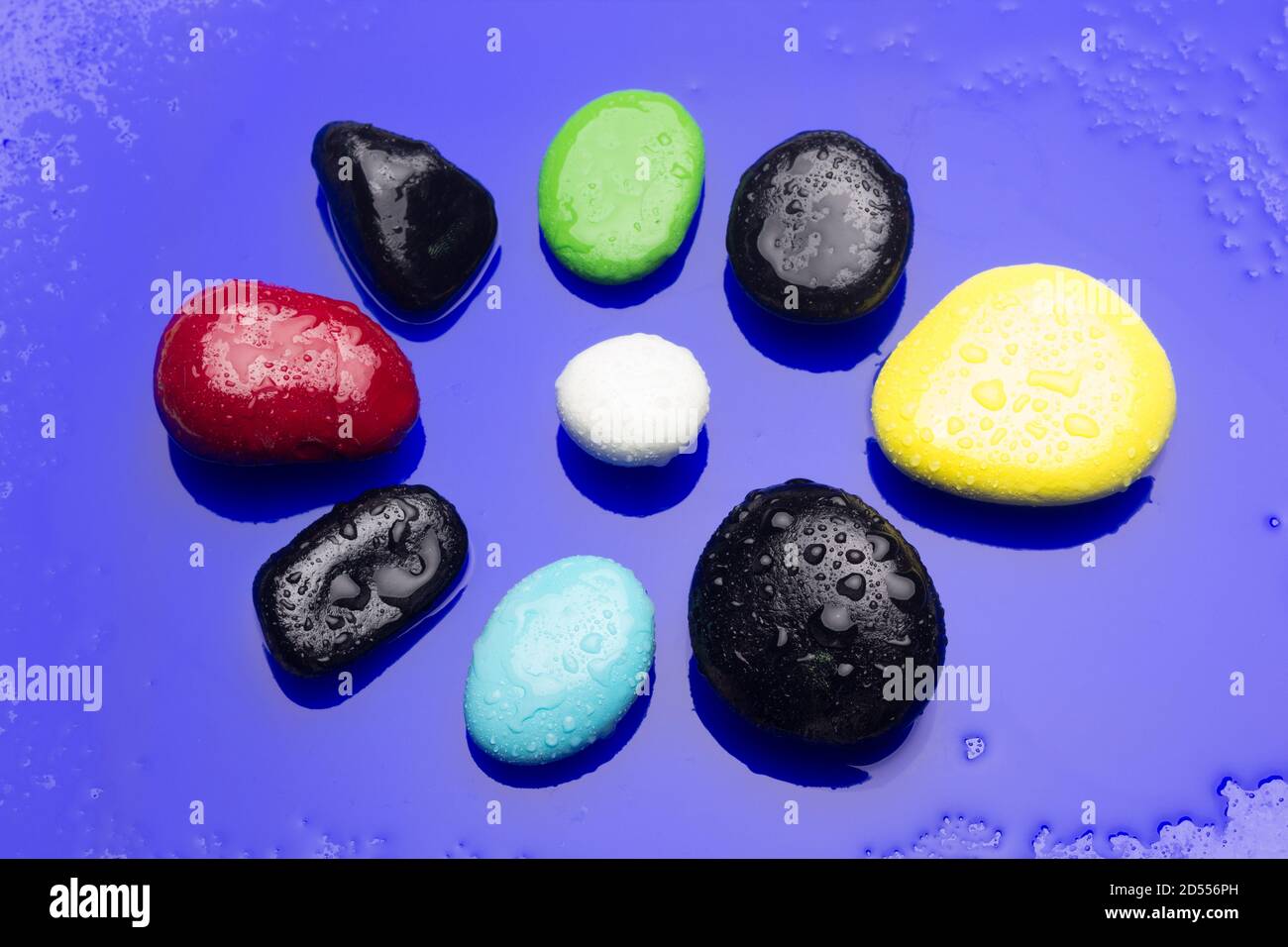 Color stones on a green background; various colors, yellow, black ...