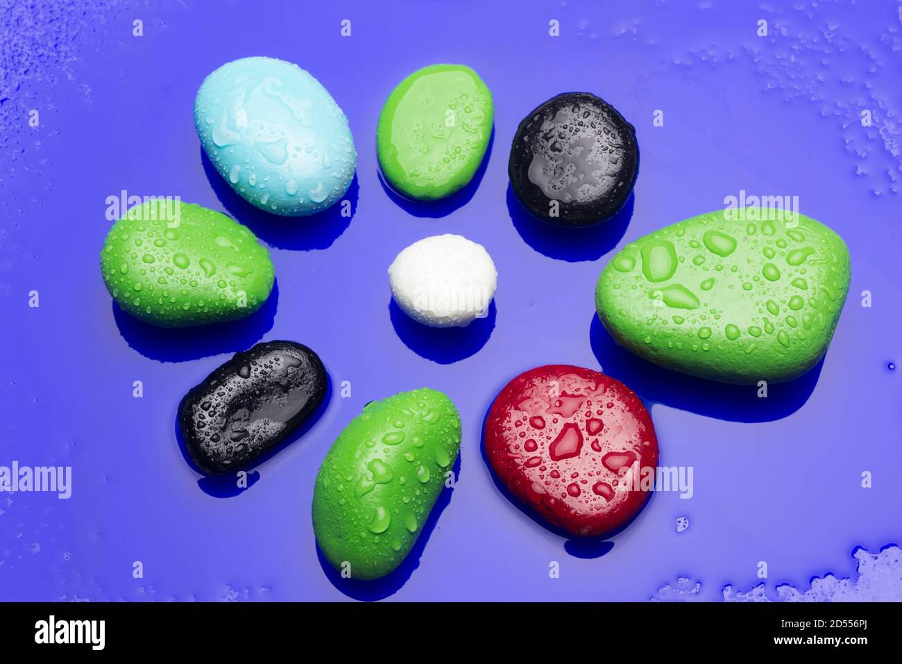 Color stones on a green background; various colors, yellow, black ...