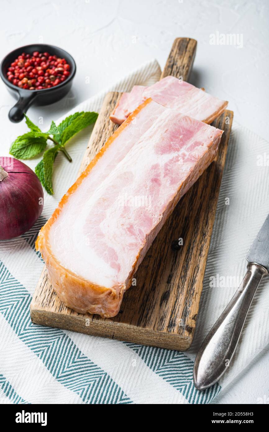 Smoked bacon, whole slab with herbs on white background Stock Photo - Alamy
