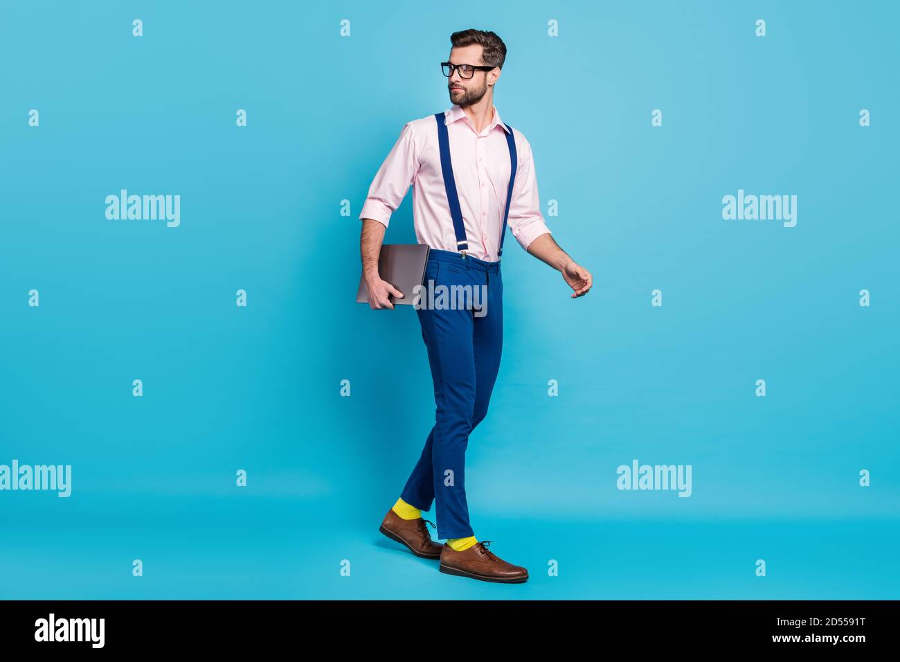 Full size photo of handsome confident business guy hold computer walk ...