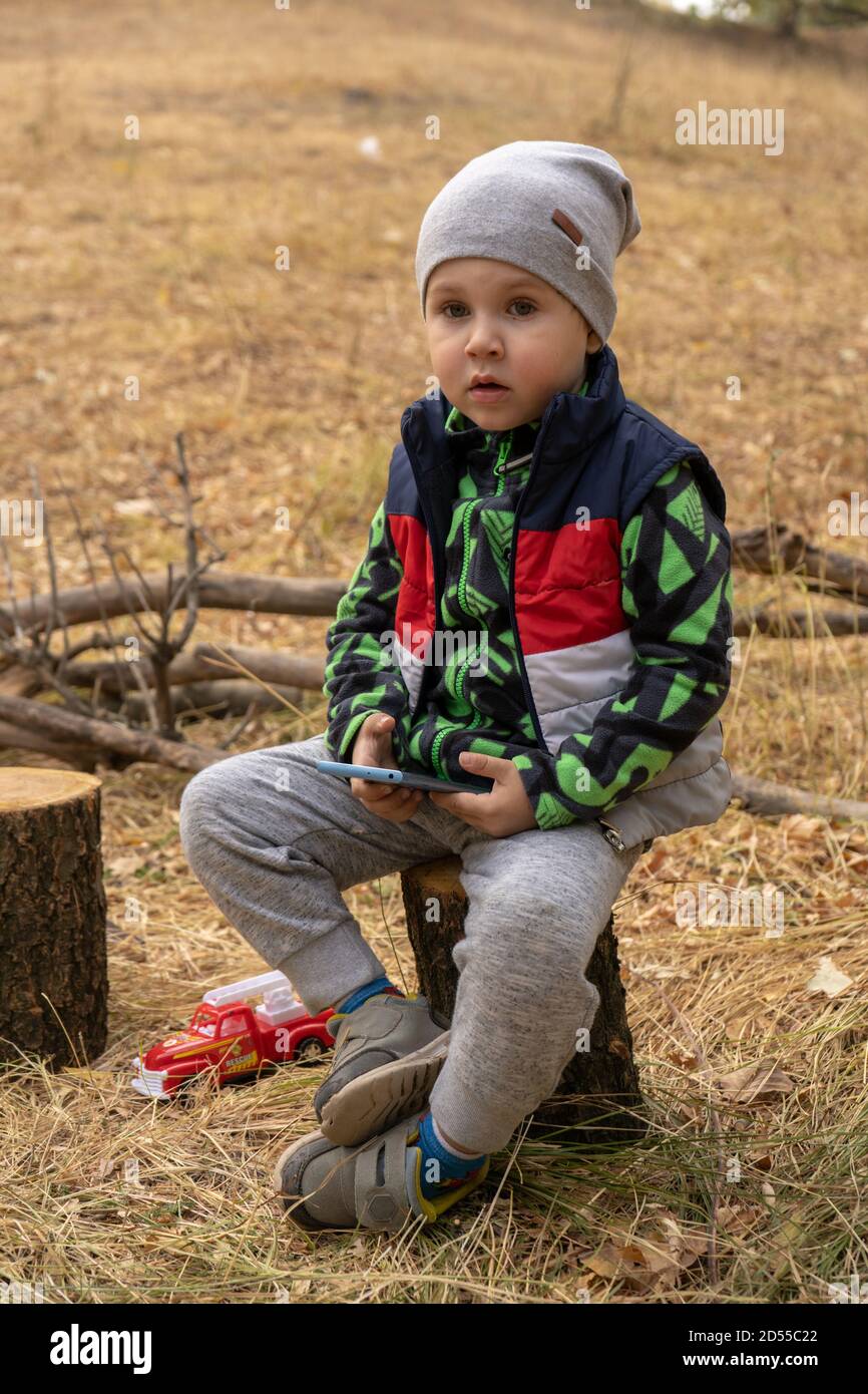 Boy sitting on log in forest hi-res stock photography and images - Alamy
