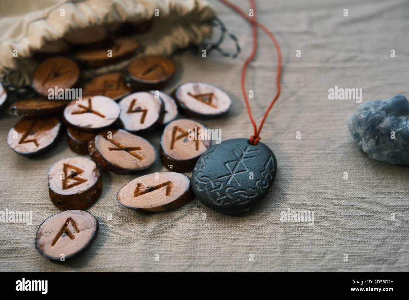 wooden runes in a canvas bag with a stone runescript Stock Photo - Alamy