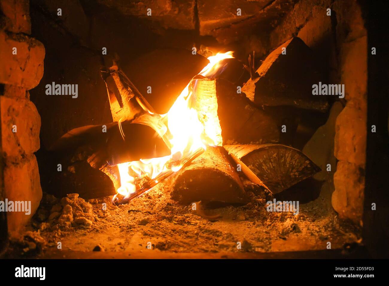 Warm light of a burning bright fire in a fireplace in old Russian stove ...