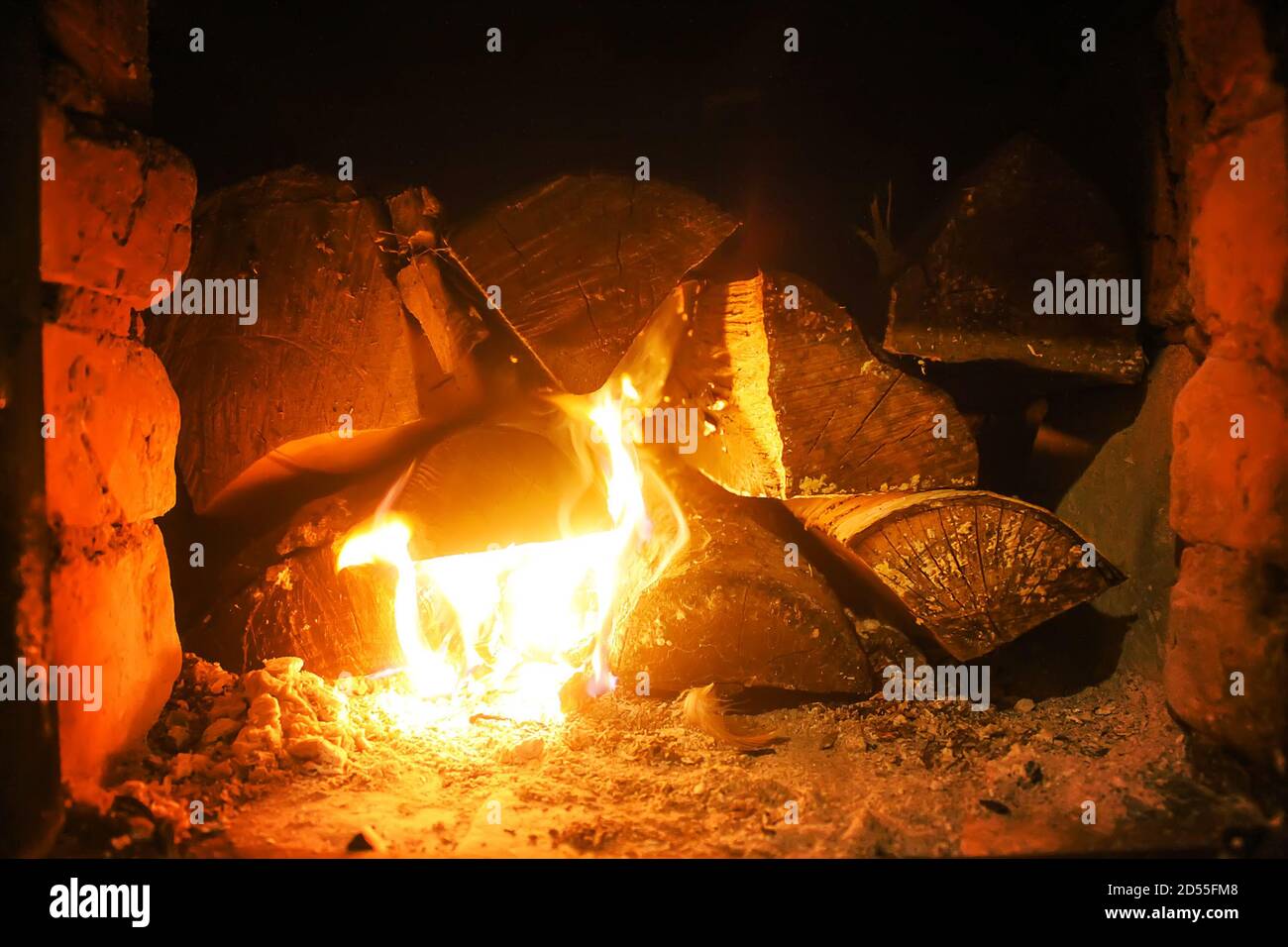 Warm light of a burning bright fire in a fireplace in old Russian stove ...