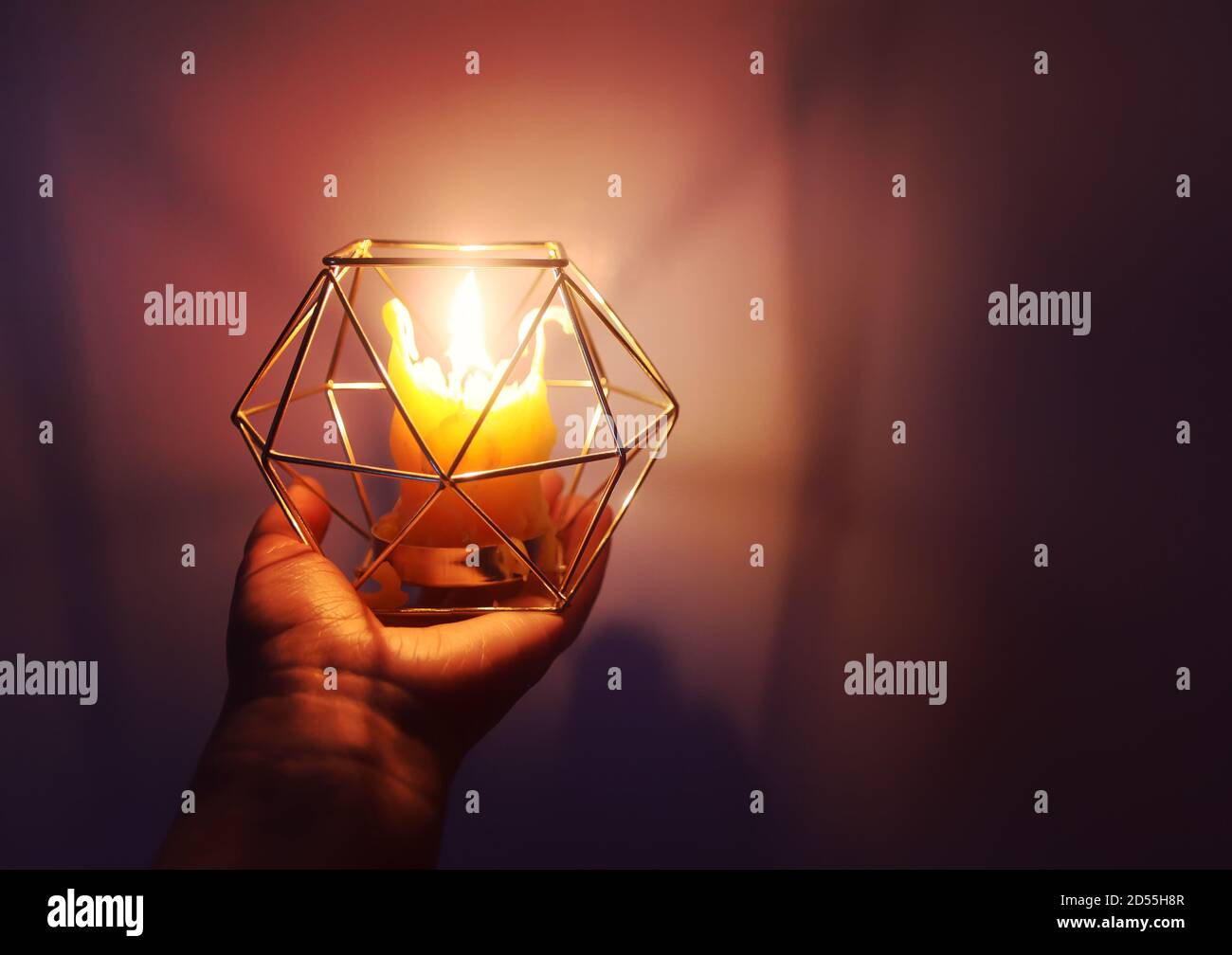 Warm light of hand made natural bee wax dying candle in a candleholder ...