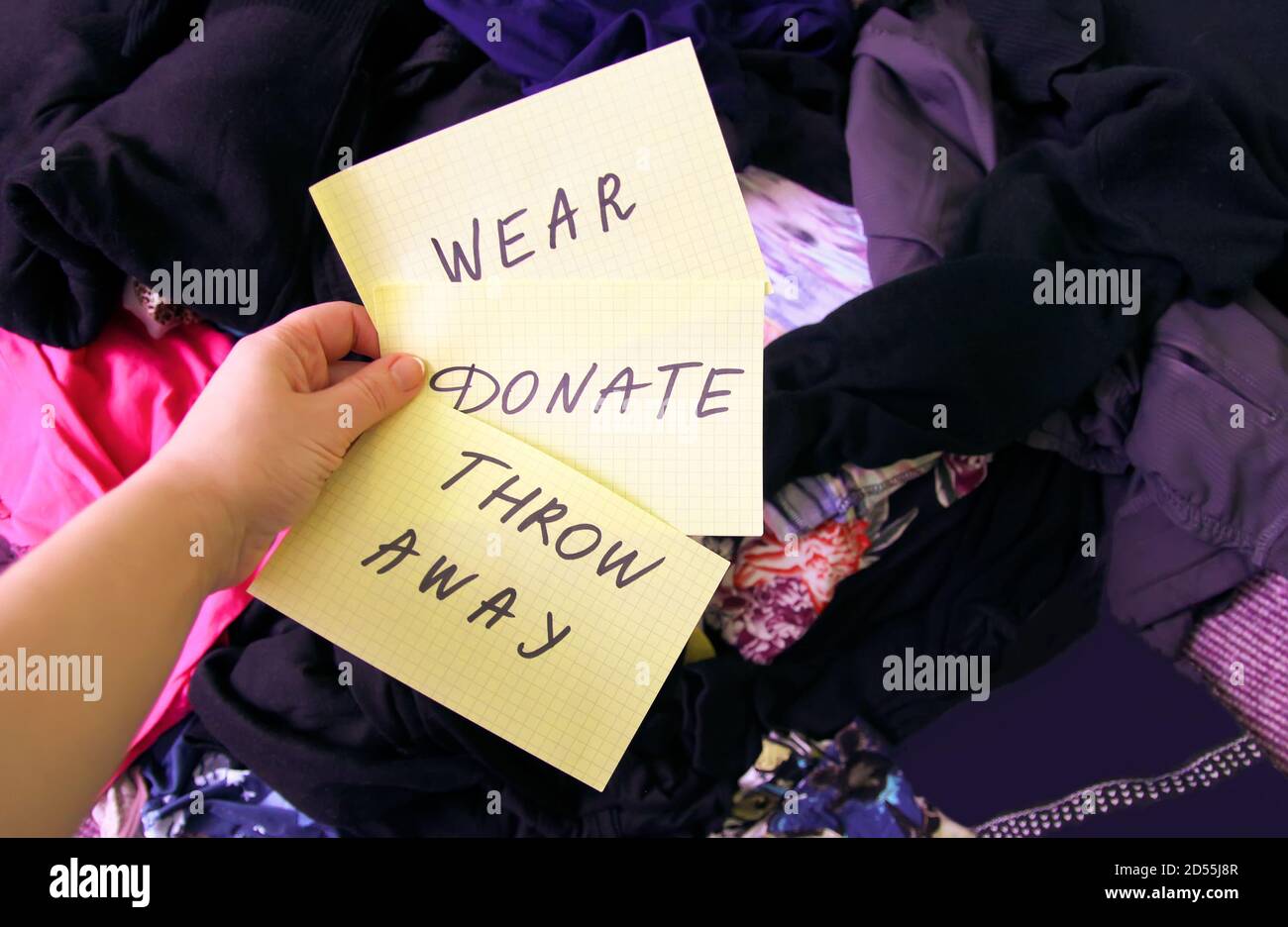 Clothes sorting on wardrobe shelf for donation, wearing and discard ...
