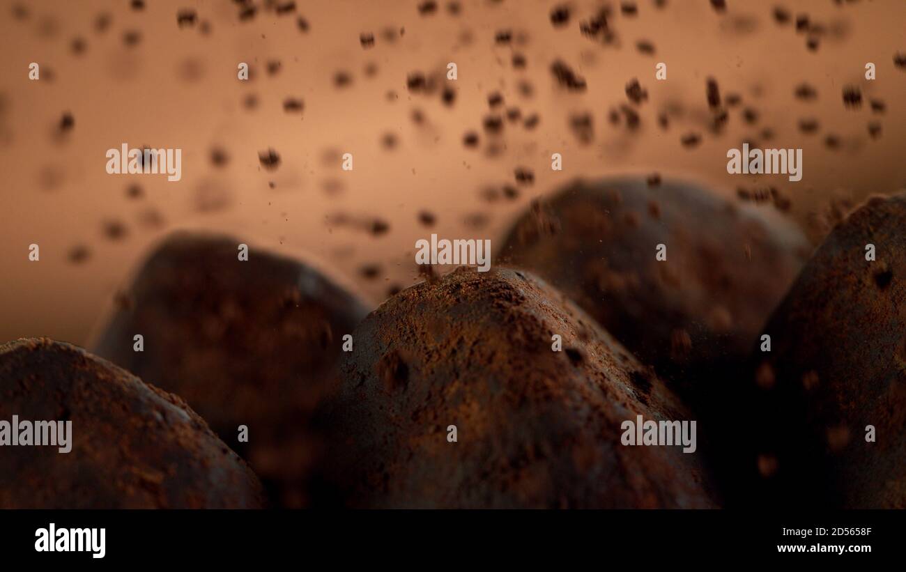 Detail of pralines with falling cocoa powder on top. Studio macro shot ...