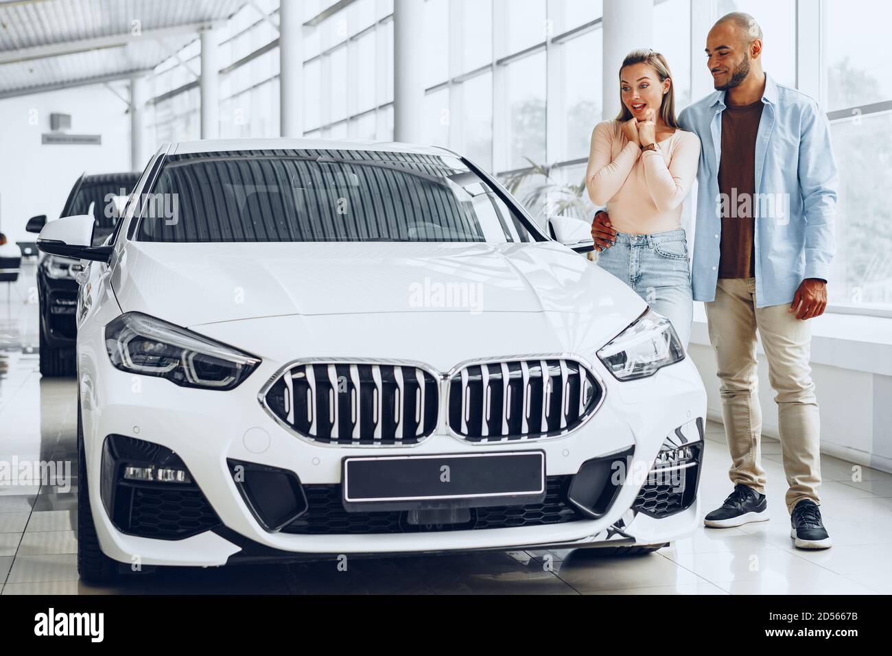 Young happy couple choosing a car in car dealership Stock Photo - Alamy