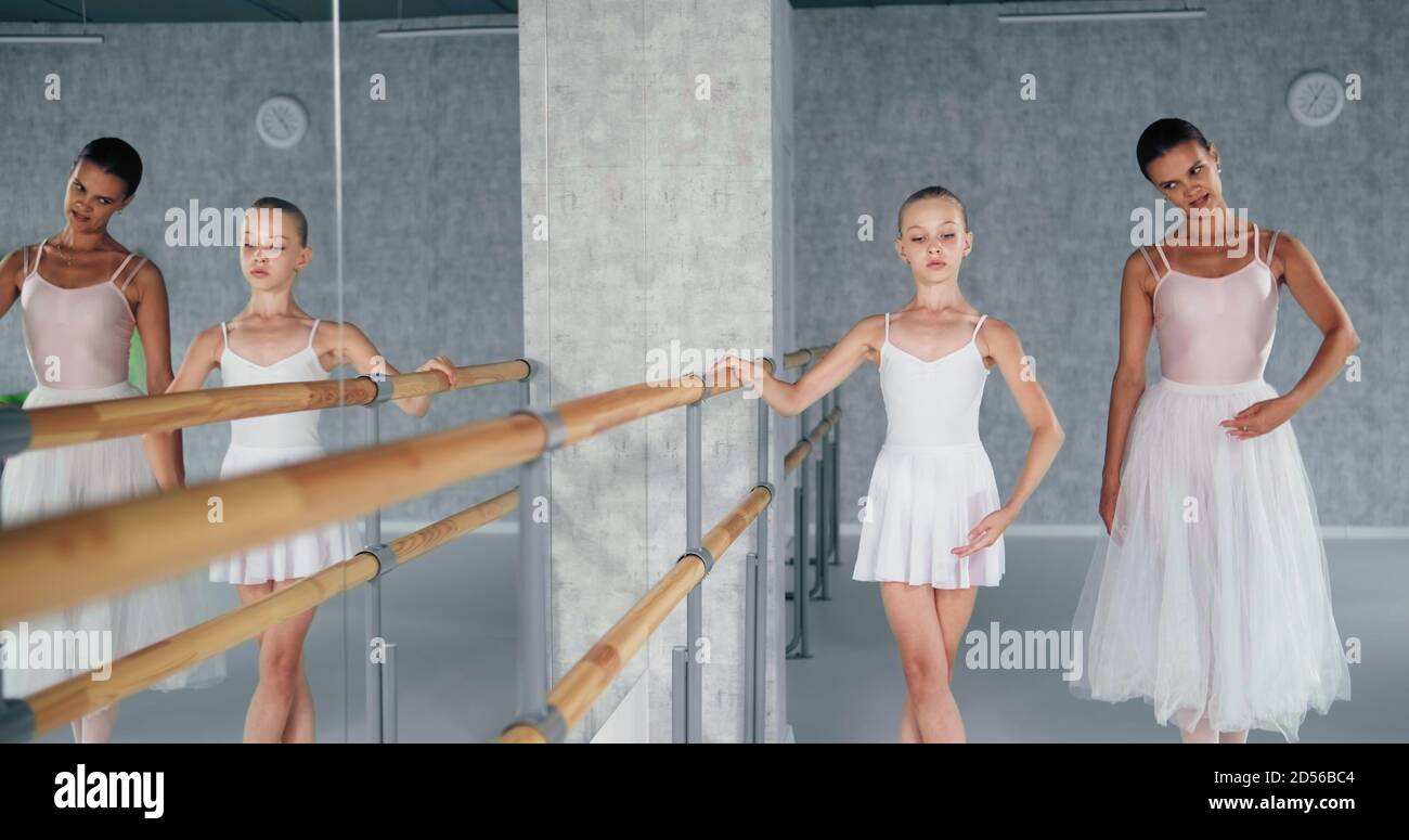 Woman teacher helps little girl ballerina do hand dance exercises ...