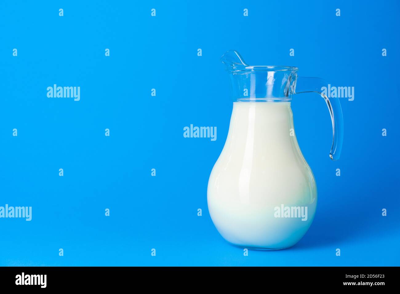 Glass jar with fresh milk against blue background Stock Photo - Alamy