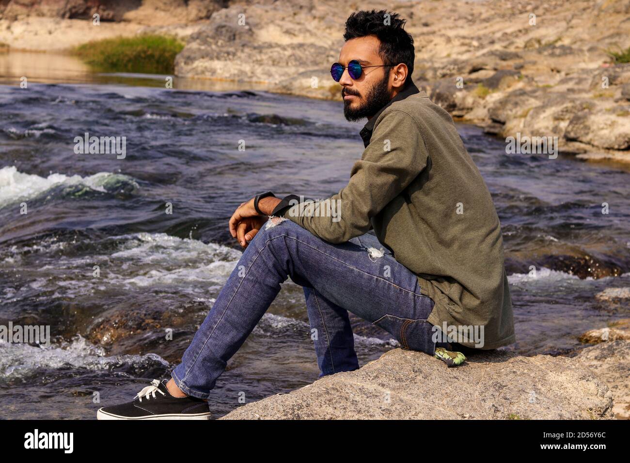 Young indian boy sitting at river side Stock Photo - Alamy