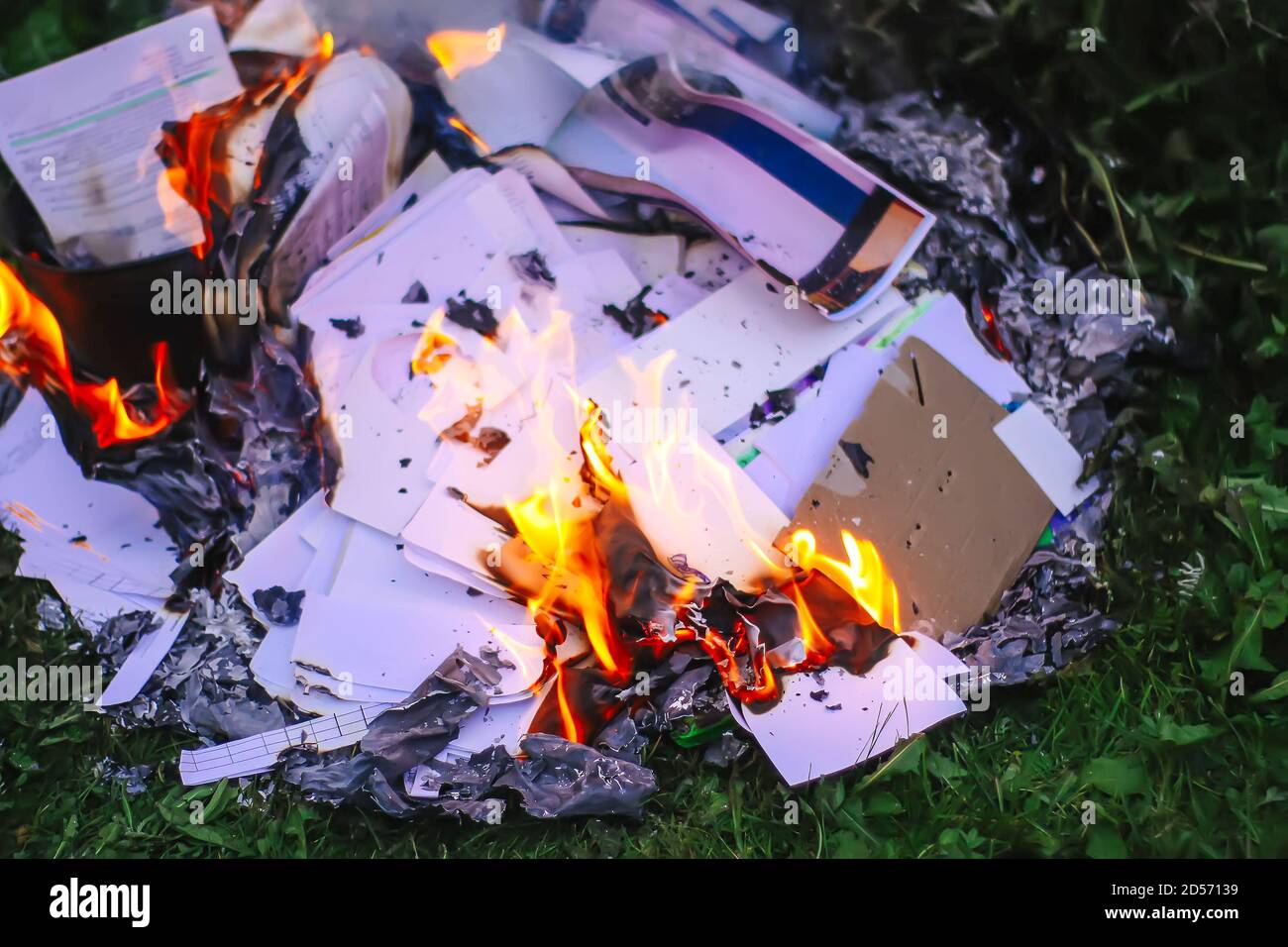 Paper burning on green summer grass outdoors Stock Photo - Alamy