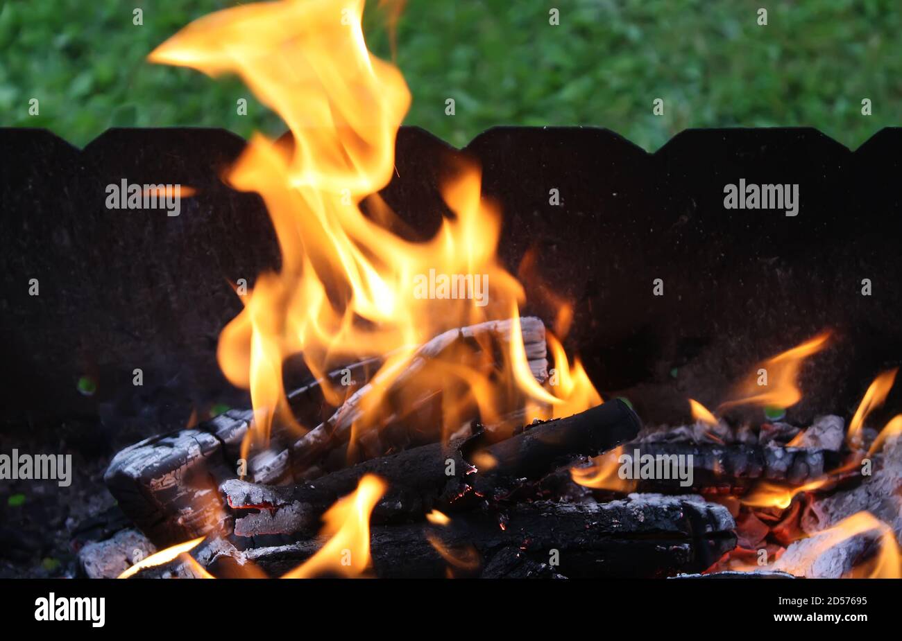 Bright flame of a burning fire above the brazier outdoors Stock Photo ...