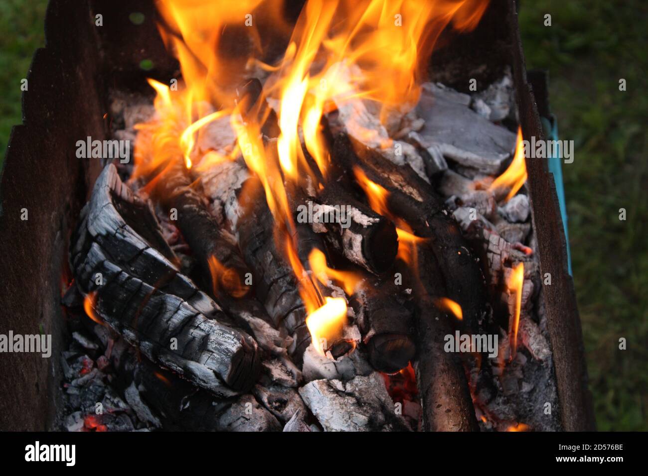 Bright flame of a burning fire above the brazier outdoors Stock Photo ...