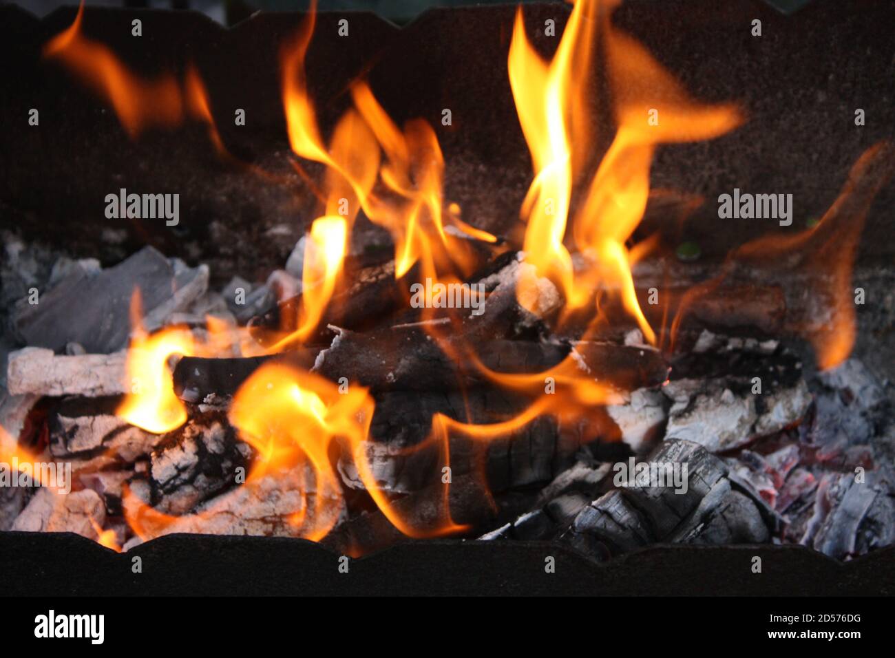 Bright flame of a burning fire above the brazier outdoors Stock Photo ...