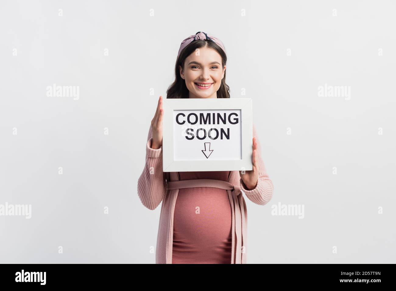 joyful pregnant woman holding board with coming soon lettering isolated ...
