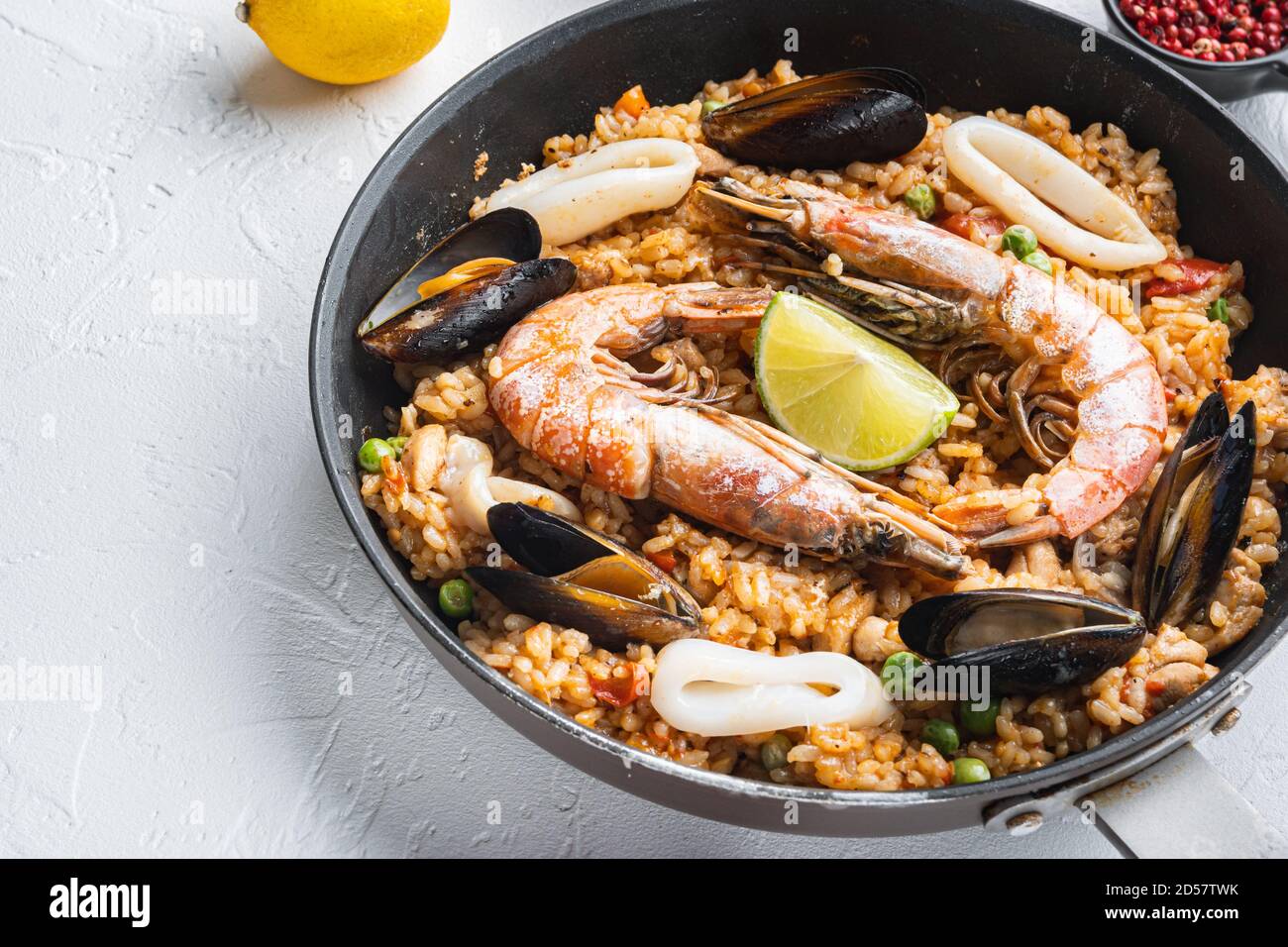 Paella cooked in frying pan on white textured background with copy ...