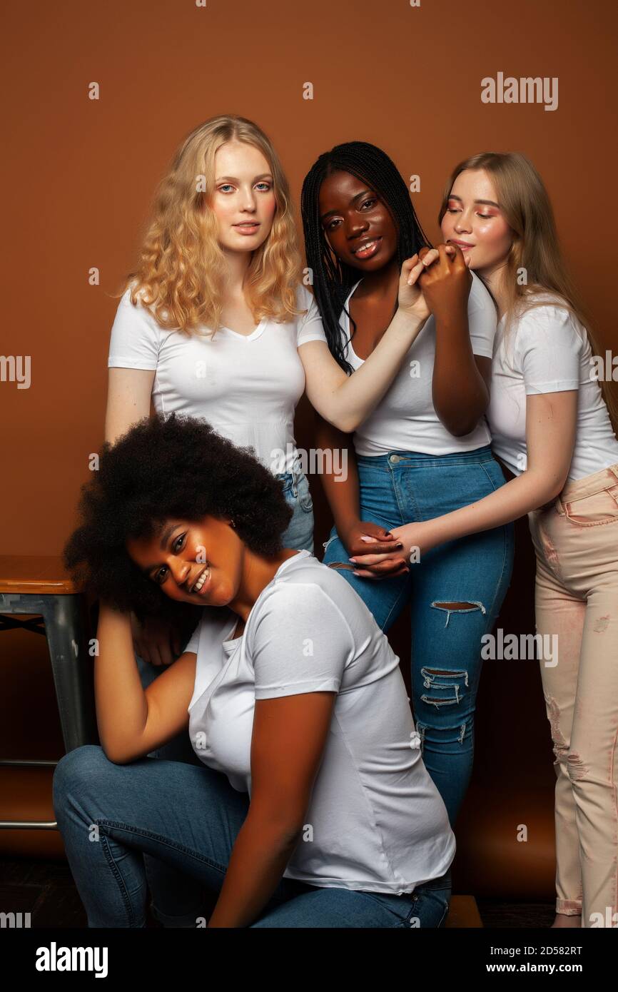 young pretty asian, caucasian, afro woman posing cheerful together on brown background ...