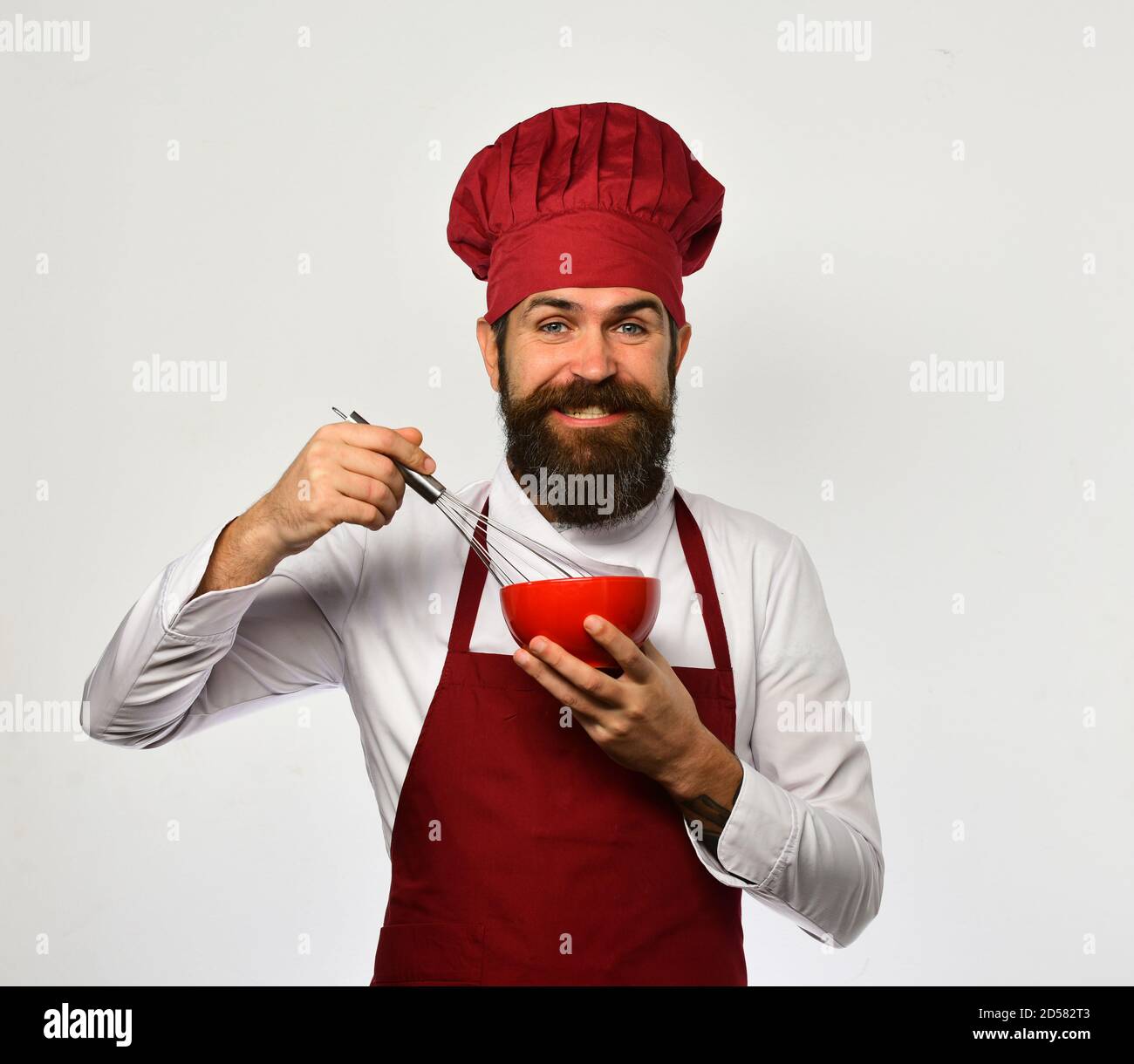 Chef mixing or whipping ingredients in red plate. Preparation process ...